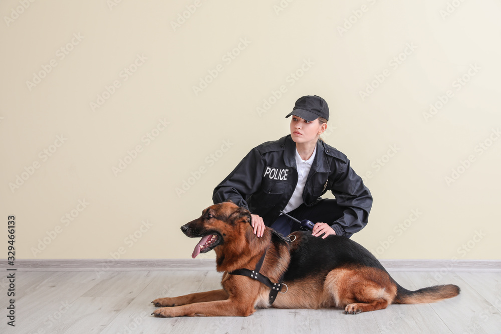 Female police officer with dog near light wall Stock Photo | Adobe Stock