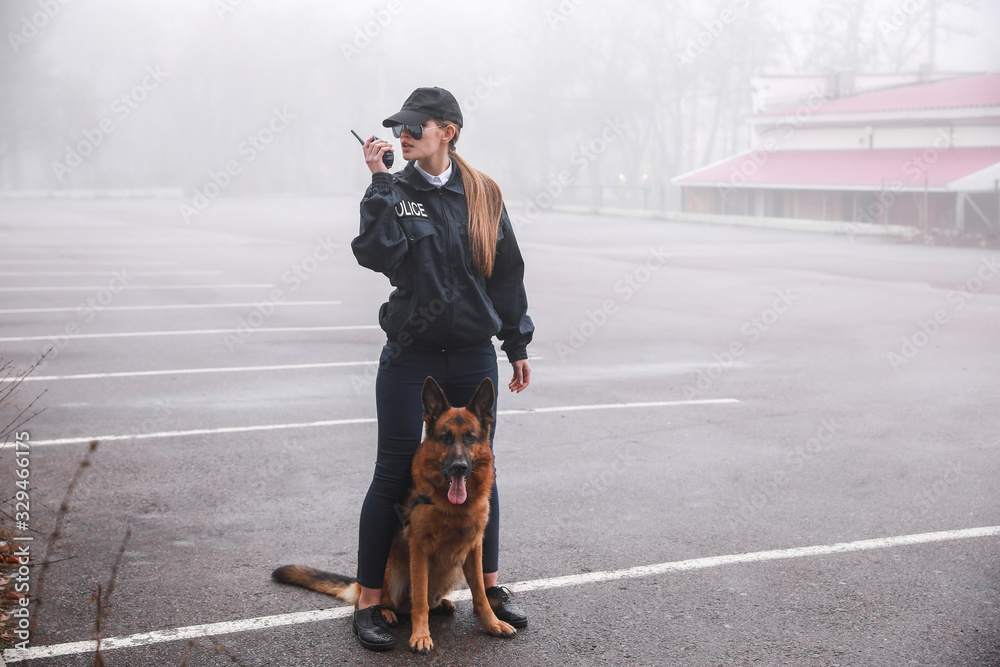 Female police officer with dog patrolling city street Stock Photo ...