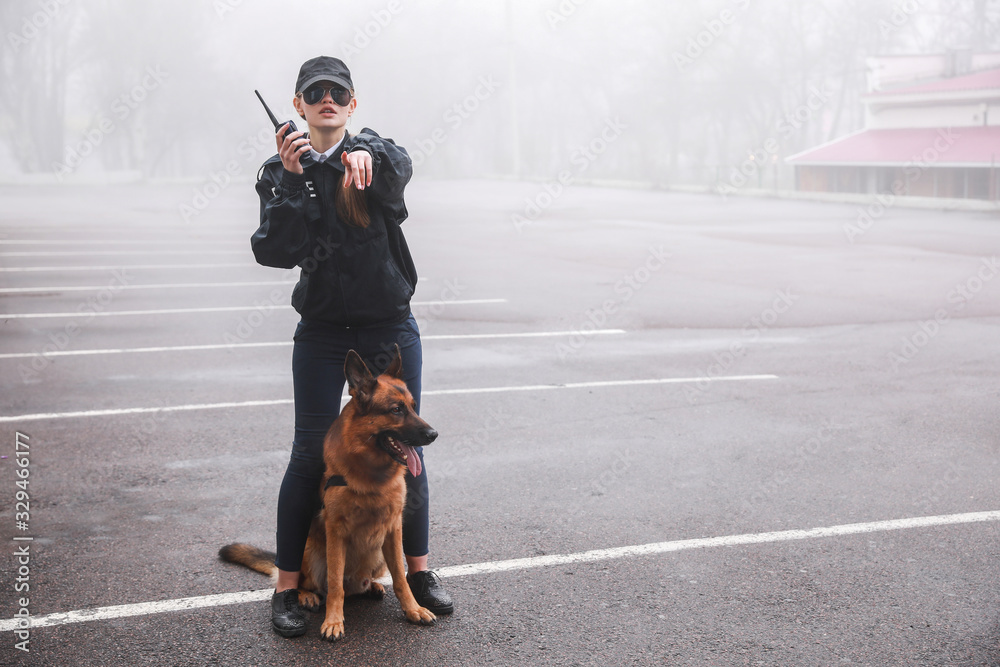 Female police officer with dog patrolling city street Stock Photo ...