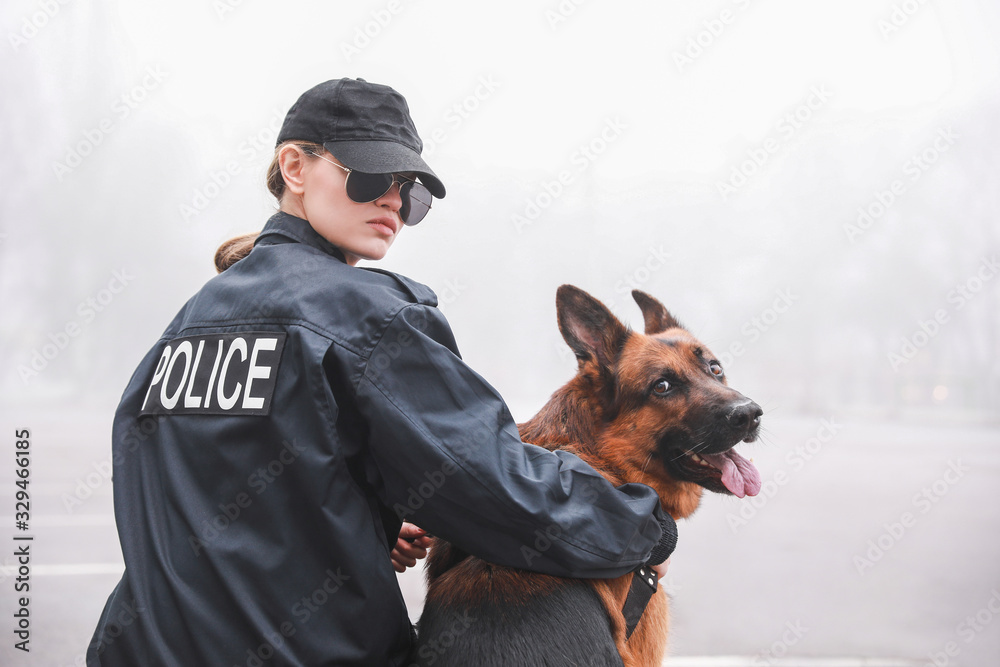 Female police officer with dog patrolling city street Stock Photo ...