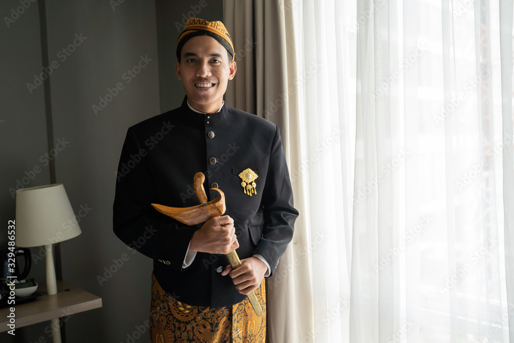 Asian man wearing traditional clothes,beskap and keris is traditional ...