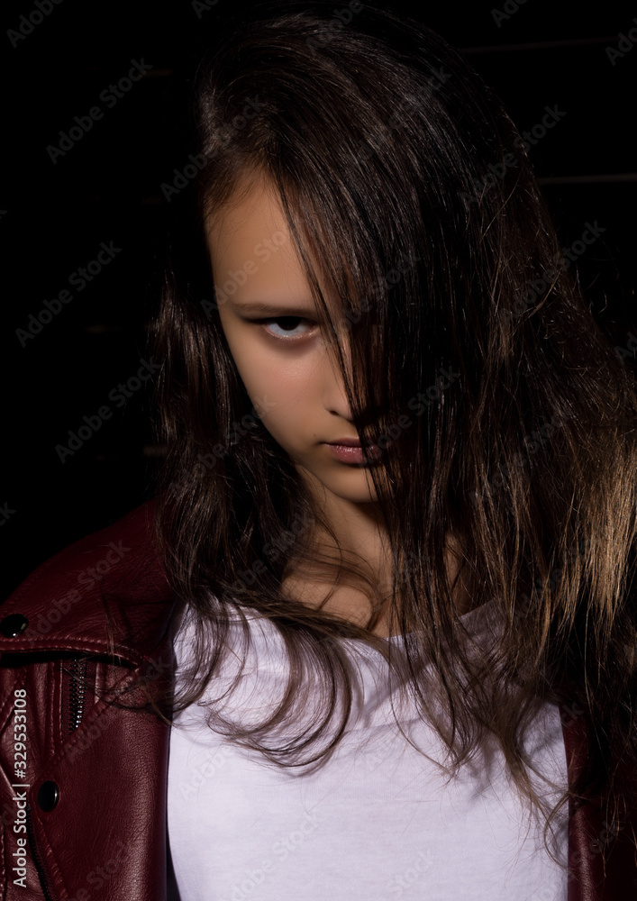 Beautyful Girl in leather jacket in a dark. Mysterious disobedient ...