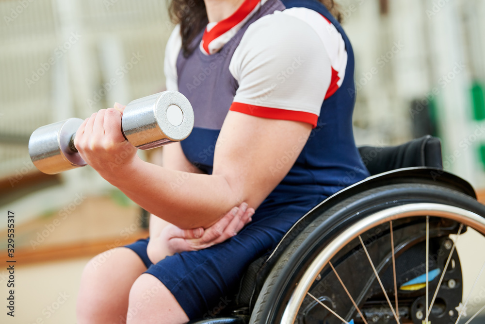 disabled woman in wheelchair lifting weight in gym. handicapped people ...