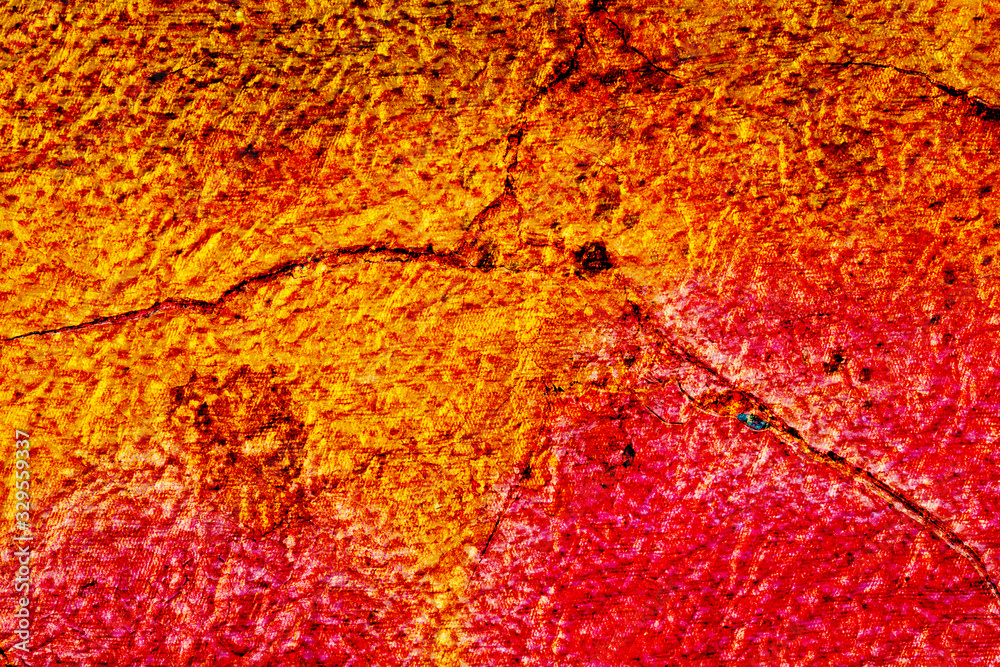 Surface texture with yellow orange and red color on a cracked surface ...