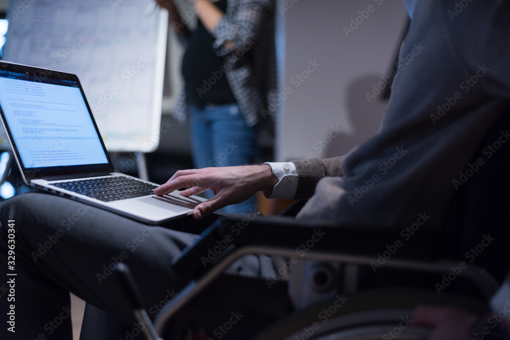 Disabled businessman in the wheelchair works in the office at the ...