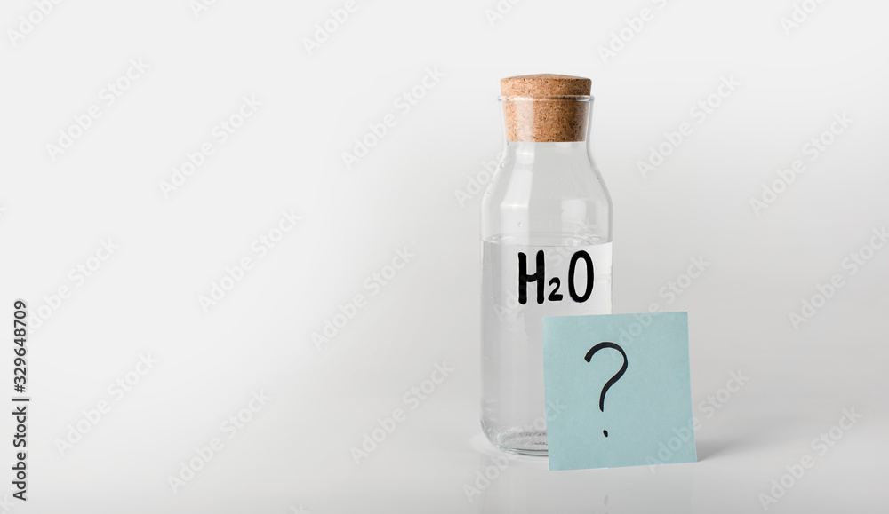 Glass bottle with the inscription chemical formula of water on it and ...