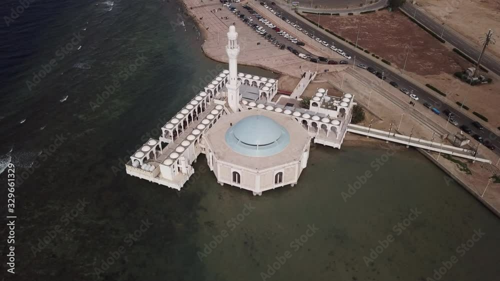 Tilting aerial footage of Al Rahma floating mosque (built on stilts) on ...