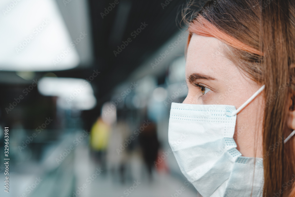 Porrait of a female person with face mask at a public place ...
