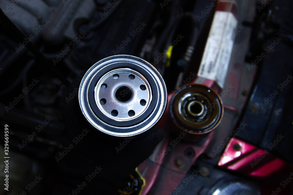 Replacing the oil filter on a car engine. new and old filter. Stock ...