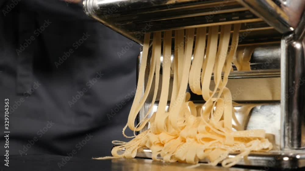 Traditional italian homemade pasta being made on hand machine for ...