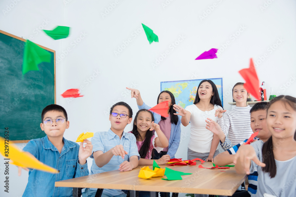 Group of asian students and a teacher throwing their paper airplane in ...