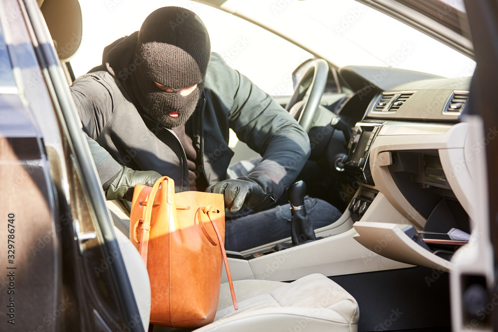 Dieb beim Stehlen aus Handtasche im Auto Stock Photo | Adobe Stock
