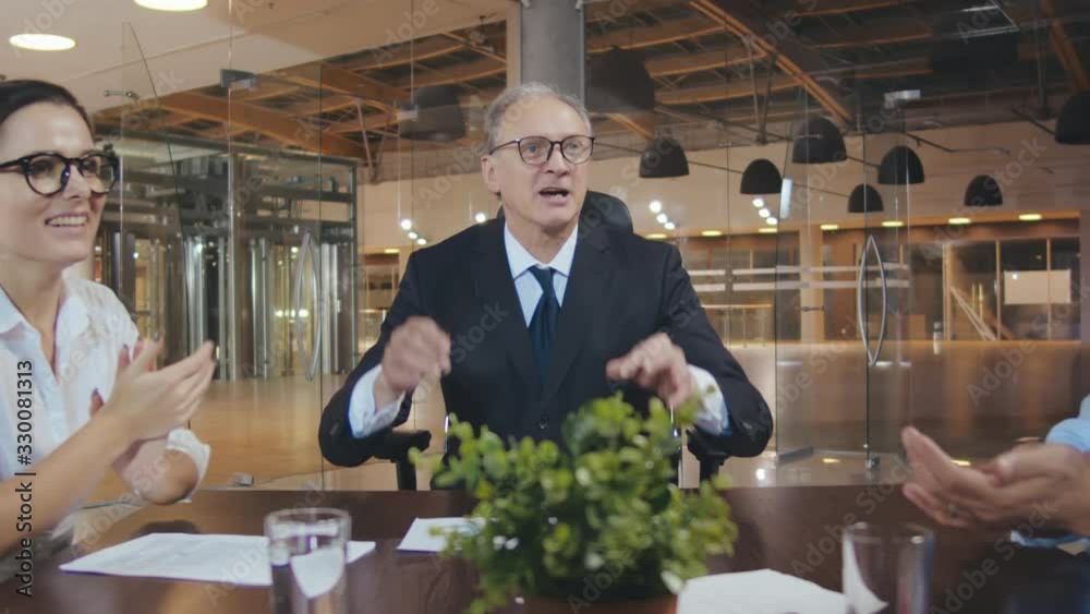 Diverse business team clapping hands and smiling during boardroom ...
