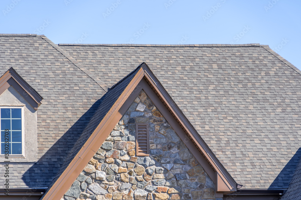 Alps style gable roof with brown frame and dark veneer stone and attic ...