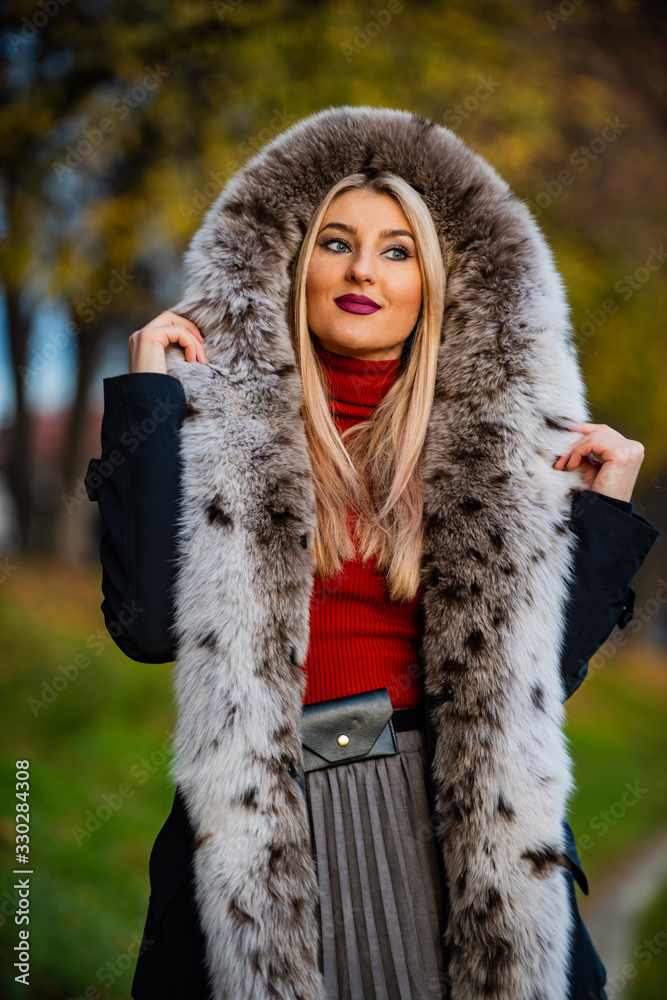 Glamour fashion model. elegant woman wear fur coat hood. beauty and ...