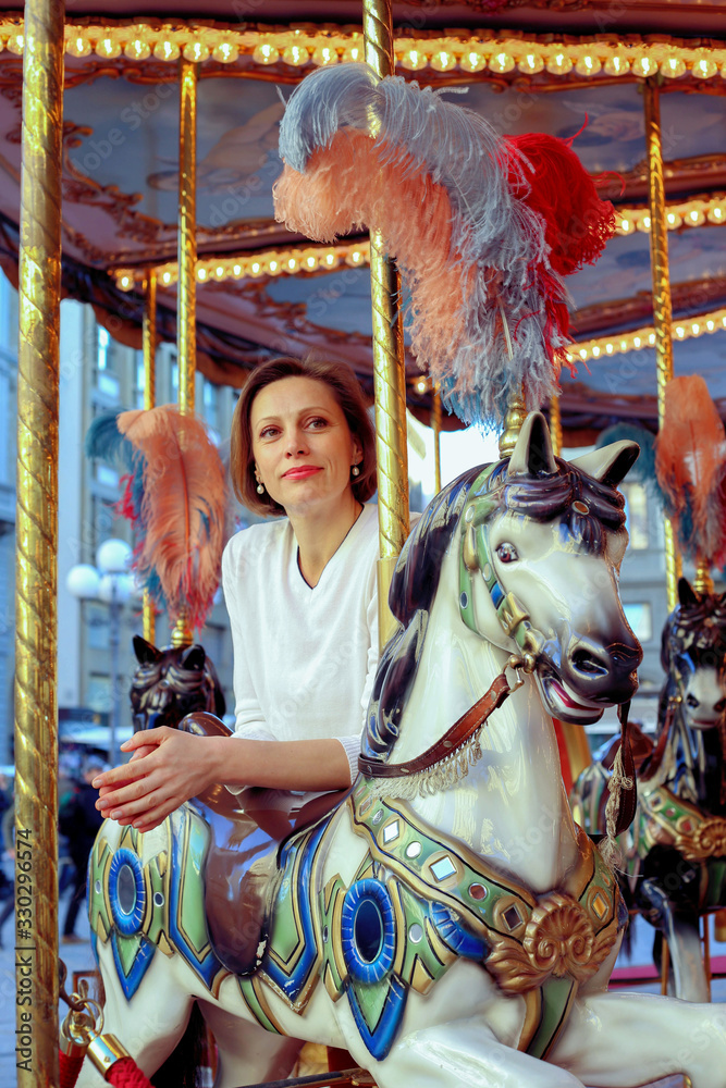 Woman riding on a traditional vintage carousel in a city park Stock ...