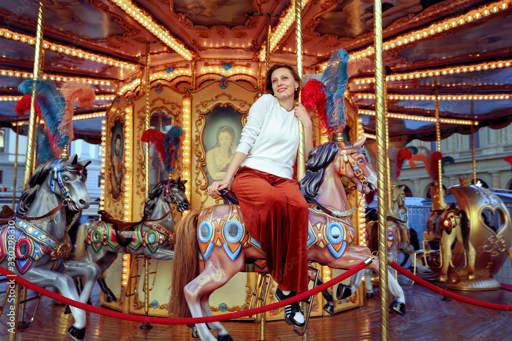 Woman riding on a traditional vintage carousel in a city park Stock ...