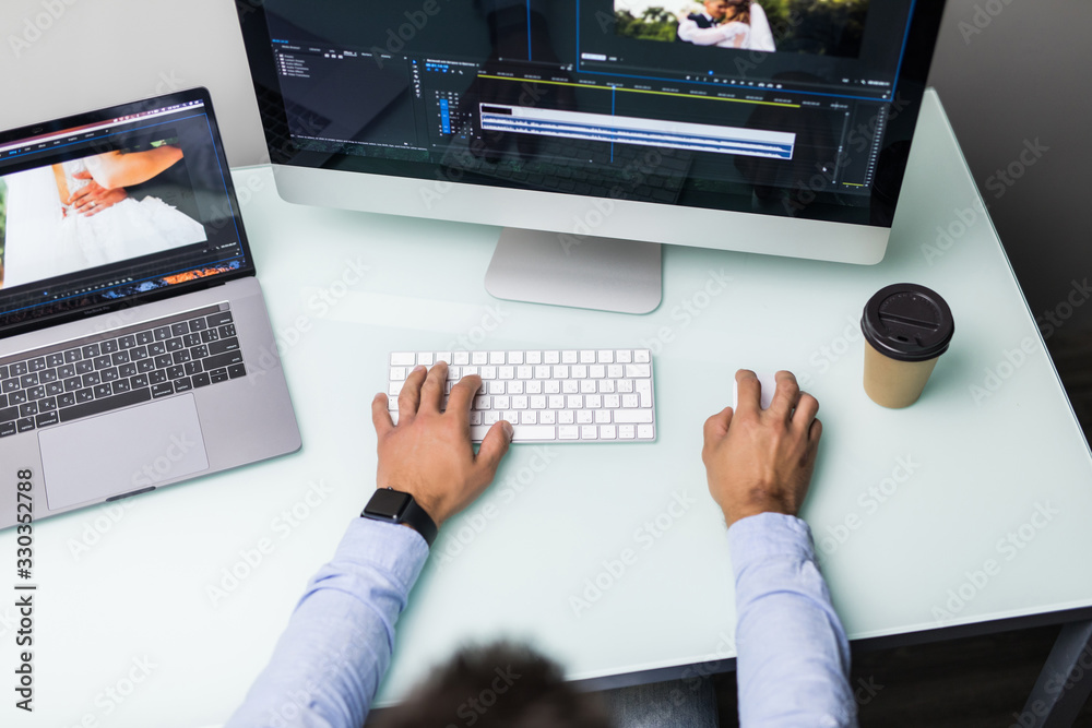 Low angle view of young man video editor with works with footage on his ...