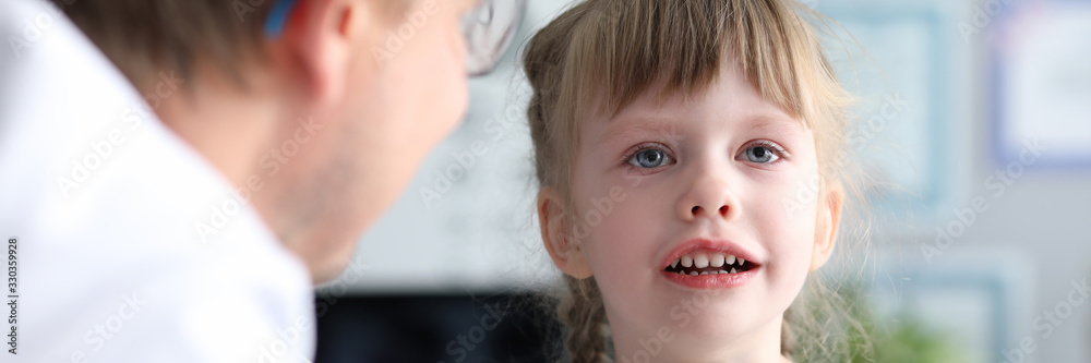 Portrait of upset child in polka-dot dress visit looking away upset ...