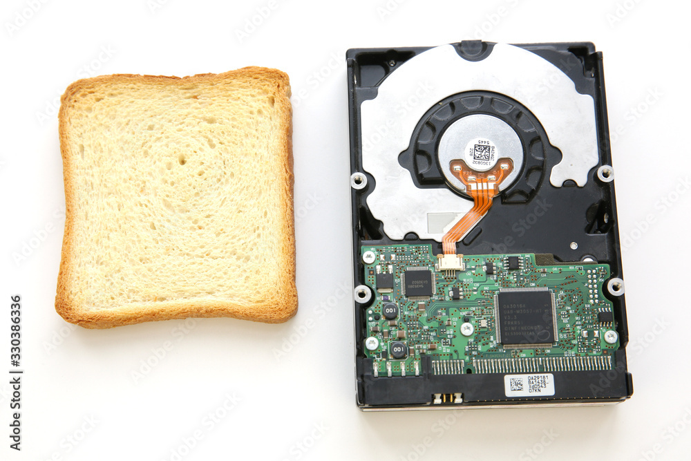 Hard drive and slice of bread crust toast isolated on a white ...