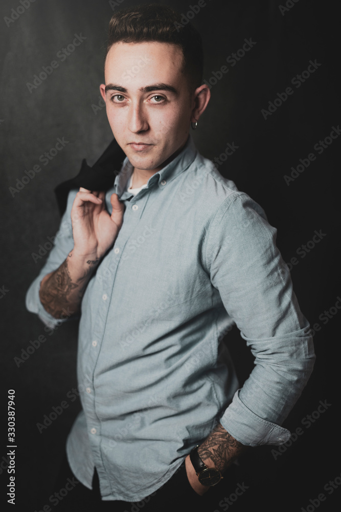 sesion de interior a un chico joven elegante y trajeado con tatuajes en ...