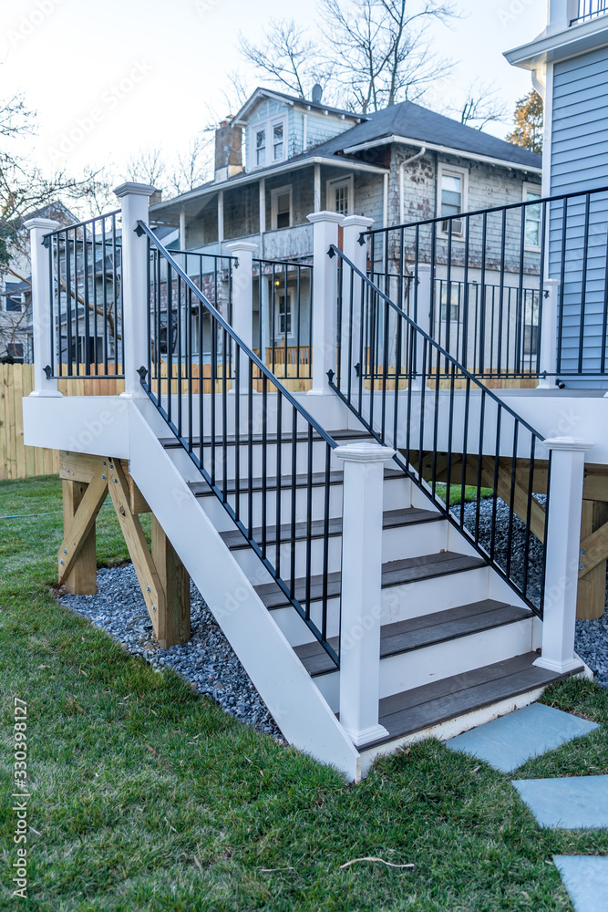 View of a classic backyard wooden deck with black metal balustrades ...
