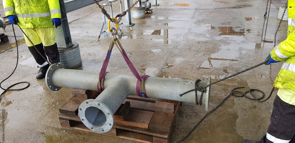 riggers move the pipe using two chain blocks Stock Photo | Adobe Stock