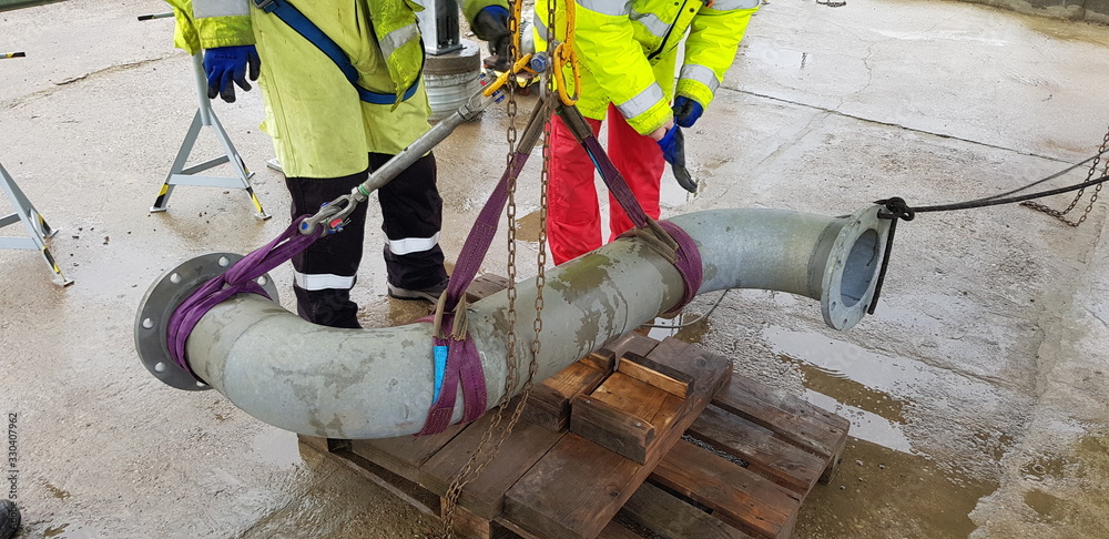 riggers move the pipe using two chain blocks Stock Photo | Adobe Stock
