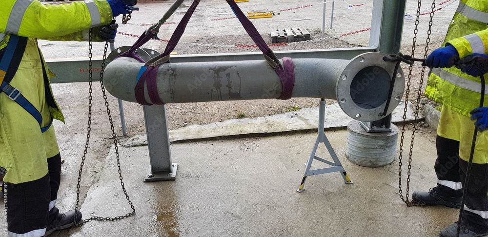 riggers move the pipe using two chain blocks Stock Photo | Adobe Stock