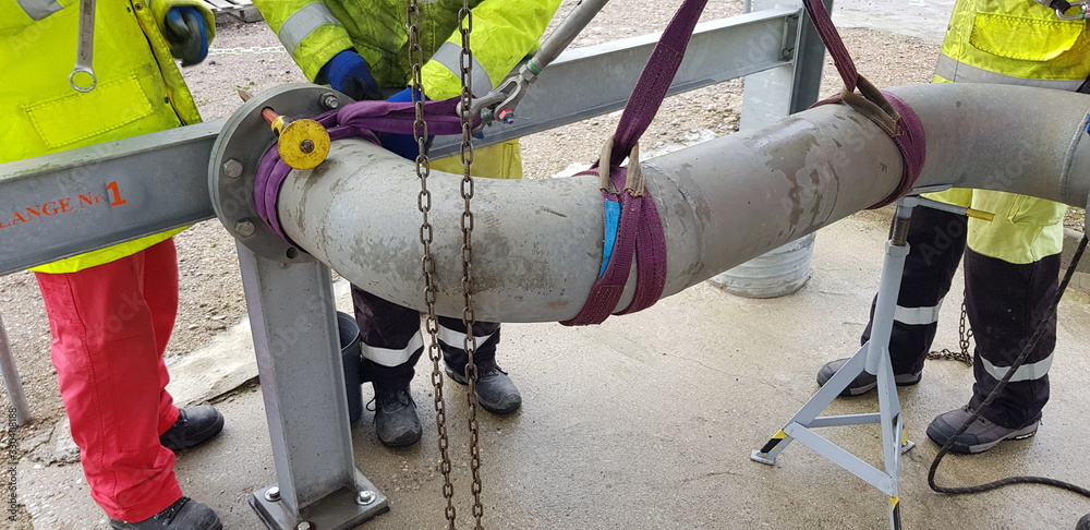 riggers move the pipe using two chain blocks Stock Photo | Adobe Stock
