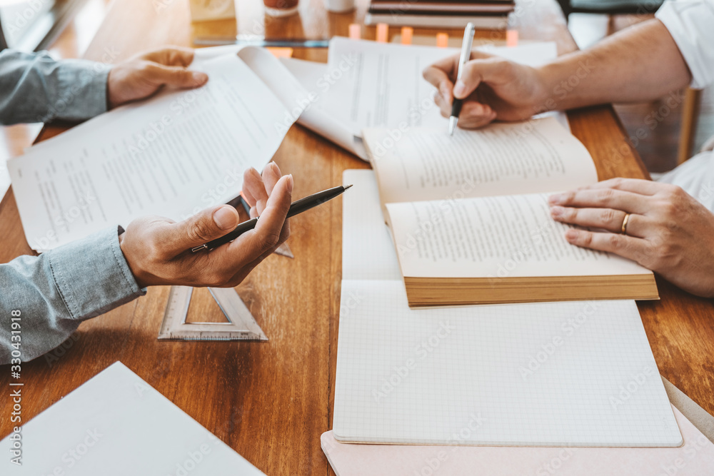 High school or college students studying and reading together in ...