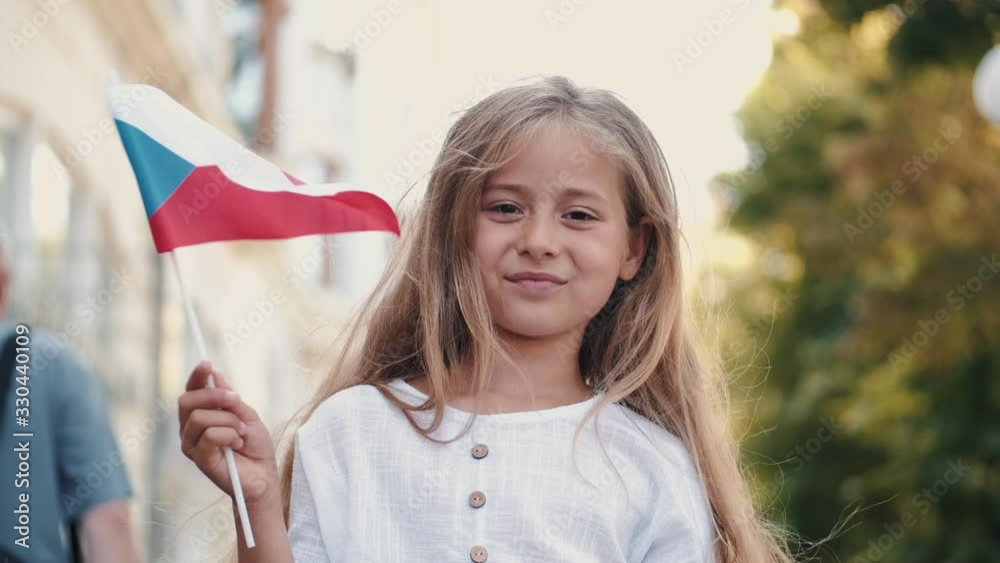 Kid wears white clothes. Little girl holds flag of Czech Republic ...