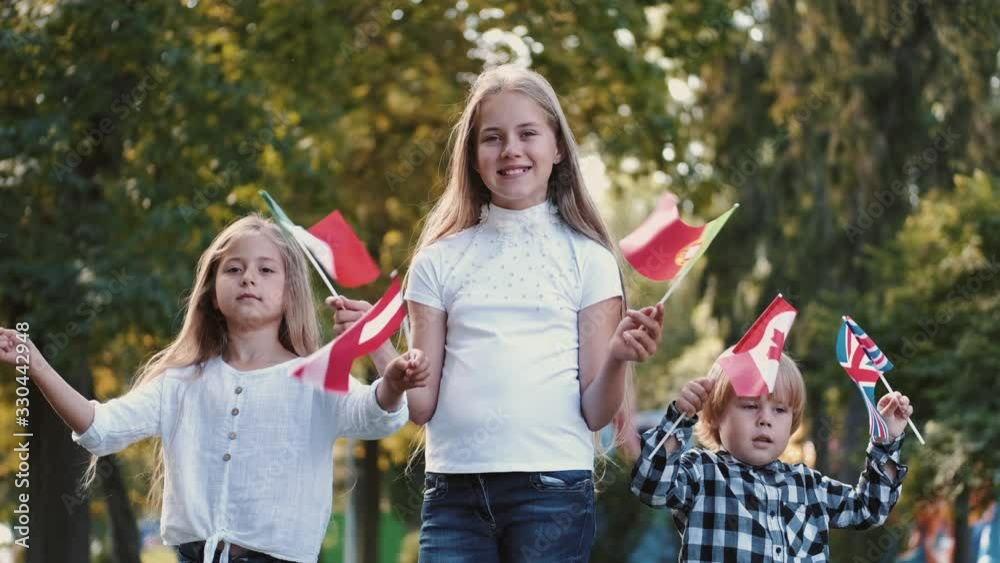 Children hold flags. The kids learn the flags of different countries ...
