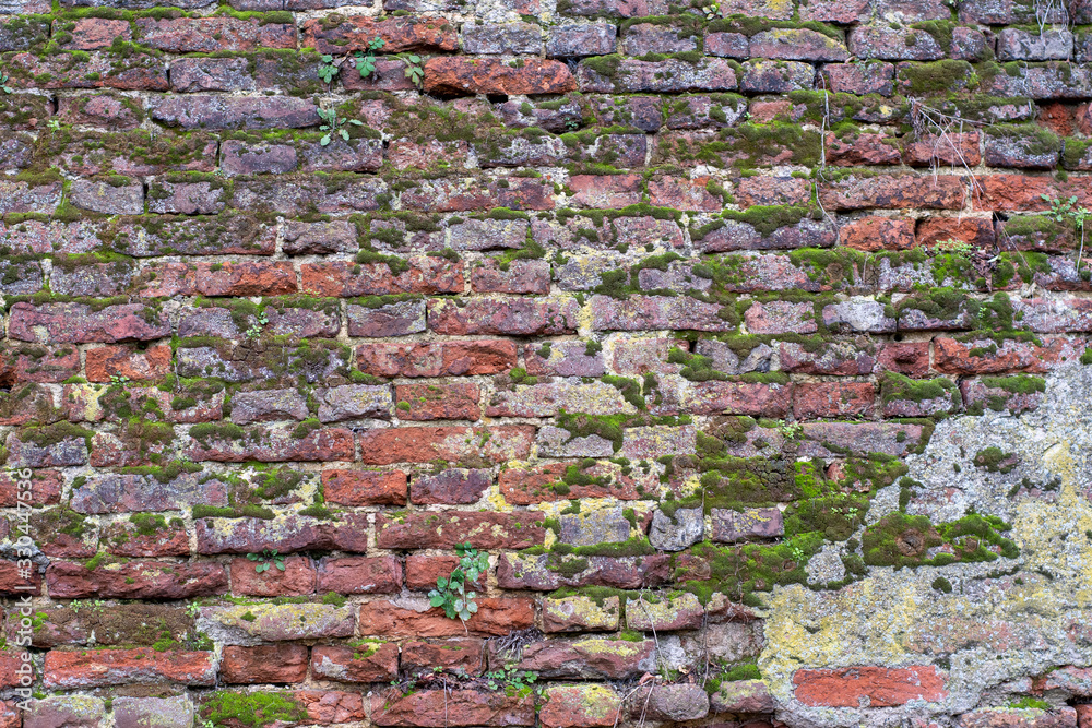 Old brick wall crumbling from old age with crumbling bricks and a ...