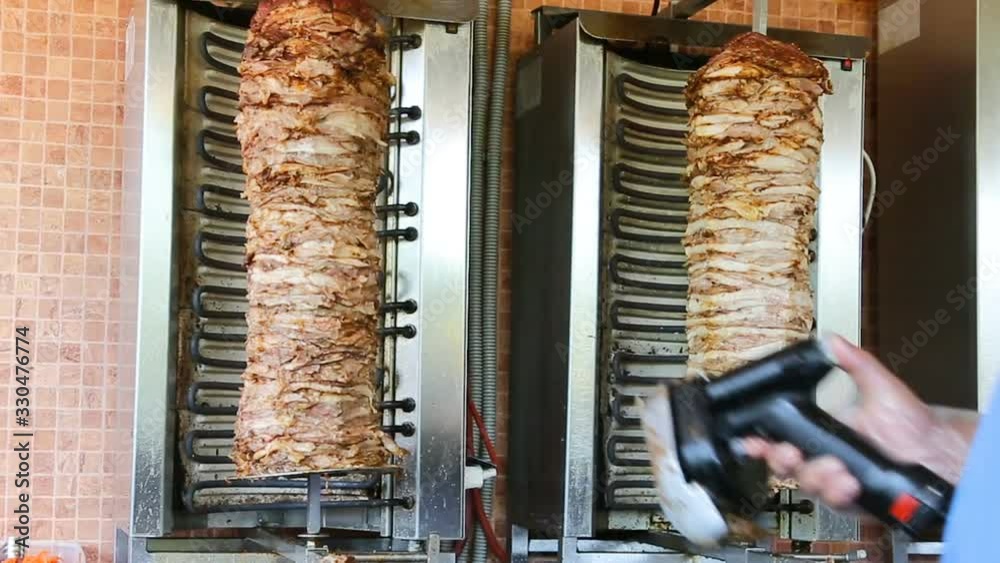 Cooking traditional fast food doner kebab meat on a rotary grill vídeo ...
