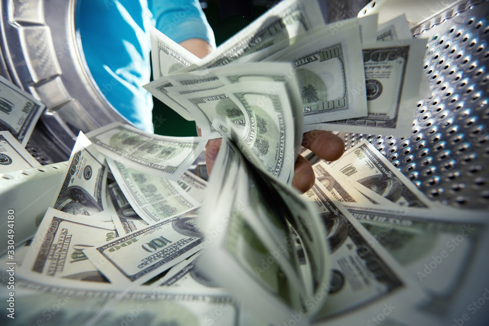 Criminal washing banknotes in machine, money laundering, financial ...