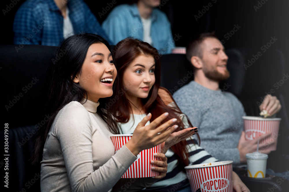 Weekend getaway. Smiling girls enjoying their movie night in cinema ...