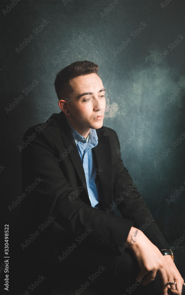 sesion de interior a un chico joven elegante y trajeado con tatuajes en ...