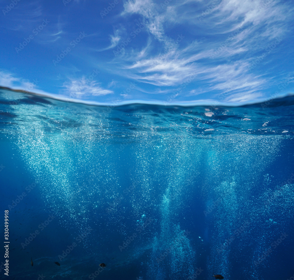 Seascape, air bubbles underwater sea and blue sky with cloud, split ...