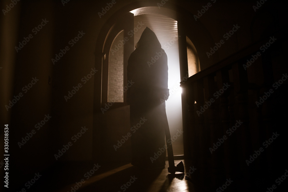 Silhouette of an unknown shadow figure on a door through a closed glass ...