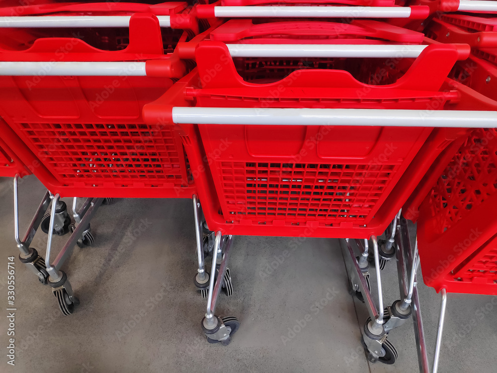 Row of red plastic shopping carts parking in the supermarket. Concept ...