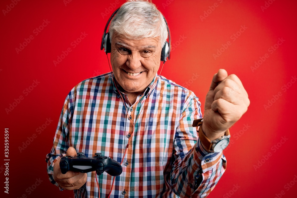Senior handsome hoary gamer man playing video game using joystick and ...