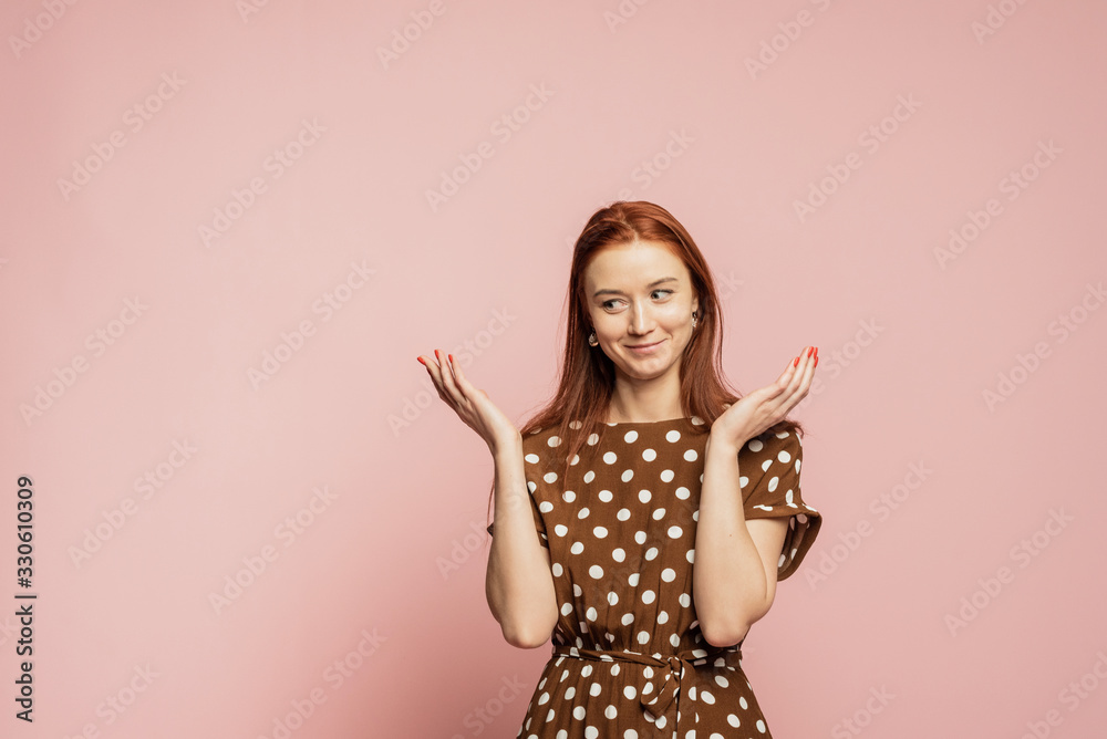 Confused and puzzled woman in the studio on a pink background. A girl ...