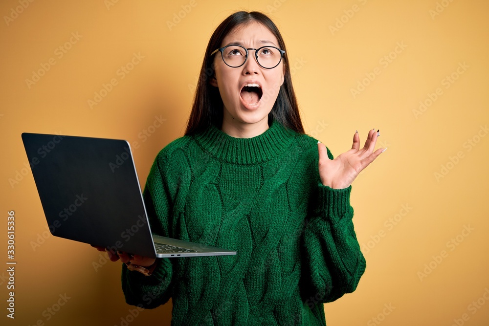 Young asian business woman wearing glasses and working using computer ...