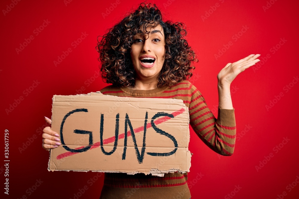 Young beautiful arab woman asking for peace holding banner with ...