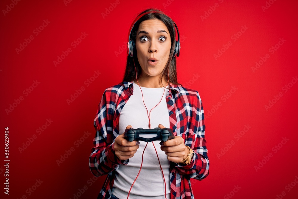 Young beautiful brunette gamer woman playing video game using joystick ...