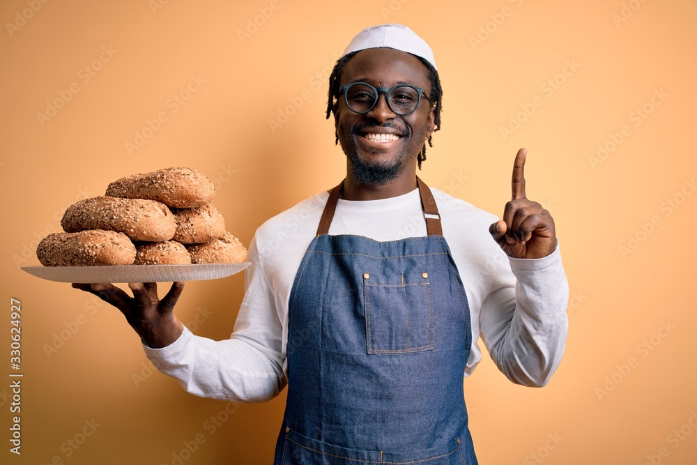 Young african american bakery man holding tray with healthy wholemeal ...