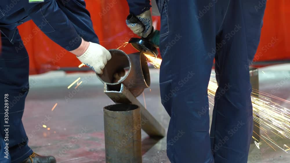 Two unrecognizable workers wear protective gloves, blue suits, use ...