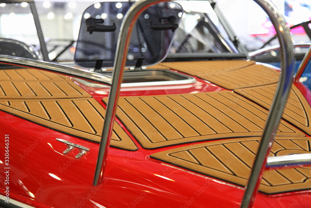 Red motor boat bow deck close up with brown marine teak coating ...