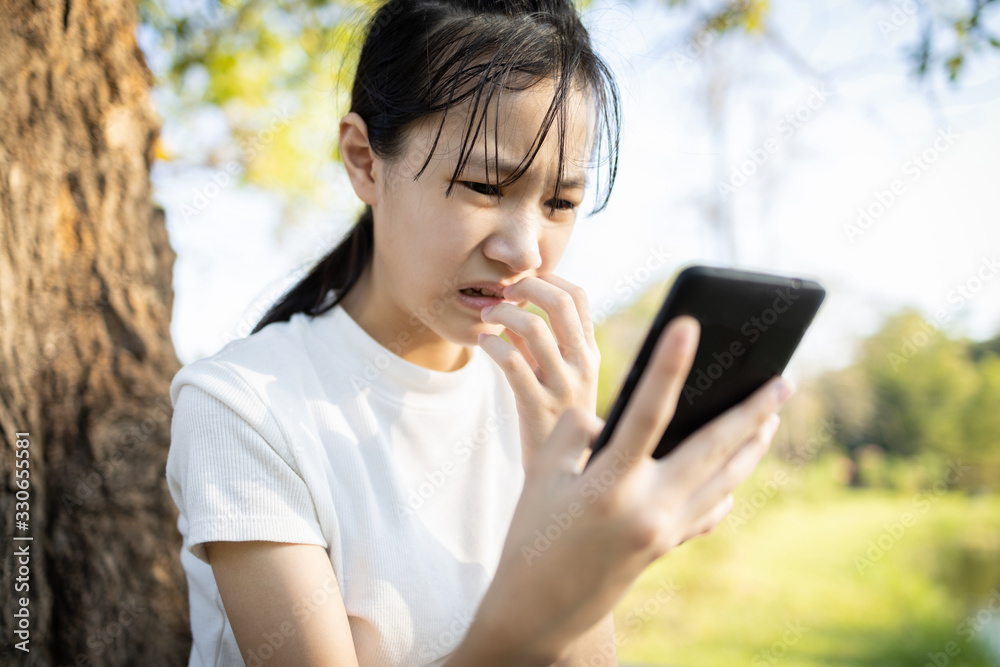 Sad female student victim of cyber bullying online sitting alone ...